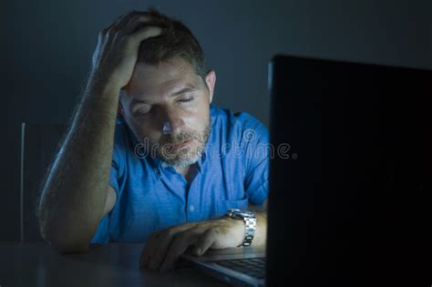 Young Attractive And Tired Unshaven Man Working Late Night On Laptop