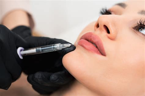 입술에 주입을 만드는 미용사 의사의 손 젊은 여자는 뷰티 페이셜 주사를 가져옵니다 얼굴 회춘 및 수분 처리 절차 미용 얼굴 미용