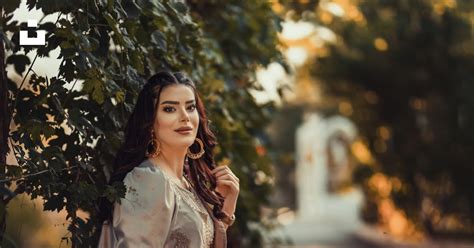 긴 드레스를 입은 여자가 벽에 앉아 있다 사진 Unsplash의 무료 테헤란 주 이미지