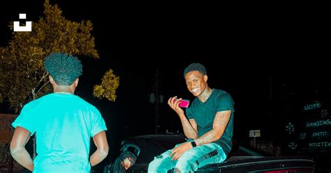 파란색 티셔츠와 파란색 데님 청바지를 입은 남자가 밤 시간에 검은 차 옆에 서 있다 사진 Unsplash의 무료 윈우드 아트