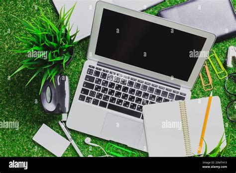 Work Setup With Laptop And Stationary On Artificial Grass In A Bright