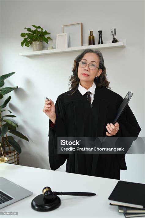 판사 변호사 또는 변호사의 초상화는 가운 가운 유니폼을 입고 문서를 들고 그녀의 사무실에 서 있습니다 법과 정의 개념 55 59세에 대한 스톡 사진 및 기타 이미지 Istock