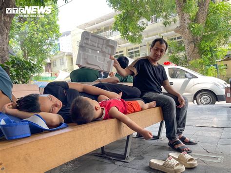 Ông bố ngồi dưới gốc cây ở bệnh viện chăm con trai ngủ giữa ngày nắng đỉnh điểm