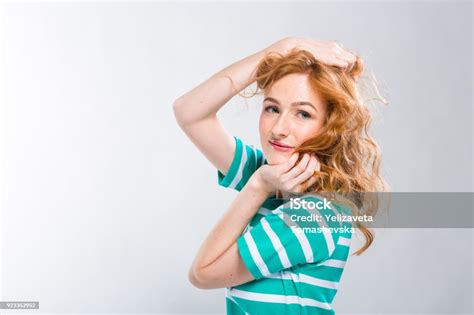 회색 배경에 스튜디오에 블루 스트립 여름 드레스에 붉은 곱슬 머리를 가진 젊은 아름 다운 여자의 클로 우즈 업 초상화 여름 휴가