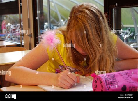 Babe In Class Writing In Her Notebook With Fluffy Pen Stock Photo Alamy