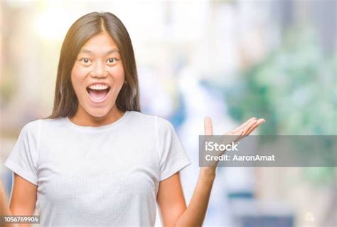 미친을 축 하 하 고 무기와 성공을 위한 흥분 비명 제기 및 오픈 눈 깜짝 놀라게 격리 된 배경 위에 젊은 아시아 여자 우승자 개념 긍정적인 감정 표현에 대한 스톡 사진 및