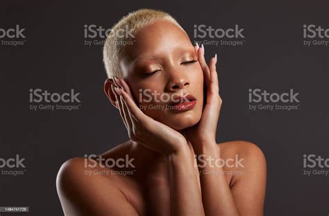 뷰티 메이크업 스킨케어 어두운 스튜디오에서 화장품을 들고 회색 배경에 격리된 플래티넘 헤어 스타일을 가진 흑인 여성 예술 미적 감각 휴식 피부 광채와 고급 스파 페이셜의