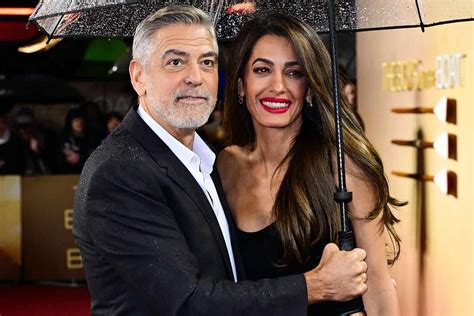 George And Amal Clooney Shelter From Rain At London Movie Screening