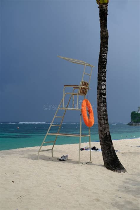 Lifeguard Chair With Orange Life Buoy On White Sand Beach With Ocean In