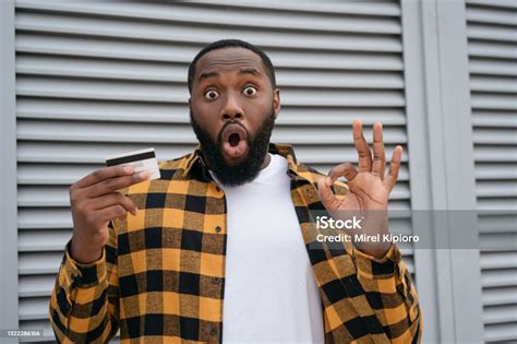 흥분 된 아프리카 계 미국인 남자 온라인 쇼핑에 대 한 신용 카드를 들고 오 기호를 보여주는 거리에 대한 스톡 사진 및 기타 이미지 Istock