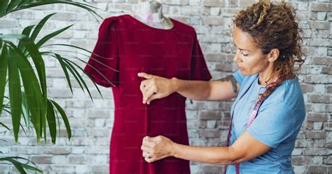 창조적 인 재단사 여성은 빨간 빈티지 드레스의 크기와 치수를 취합니다 홈 스튜디오에서 일하는 여성 사람들의 개념 재봉 및 드레스 만들기 성인 여성과 실내 레저 활동 개념