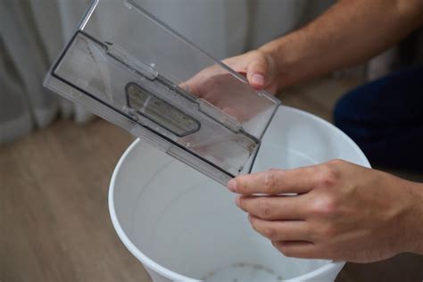 Premium Photo Cleaning The Filter Of The Vacuum Robot Cleaner From Dirt Closeup
