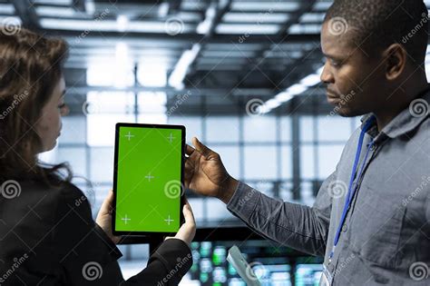 Engineers In Data Center Using Mockup Tablet Observing Analytics Stock
