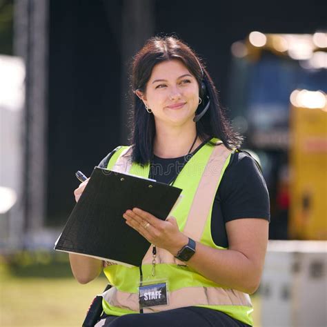 female production worker setting up outdoor stage for music festival or