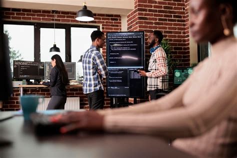 Free Photo Two Of Company Programming Engineers Analyzing Html Code Standing In Front Of Big