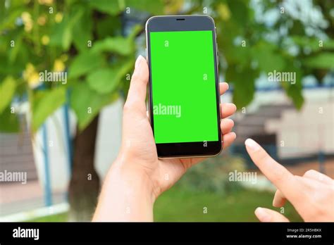 Woman using smartphone with green screen outdoors, closeup. Gadget ...