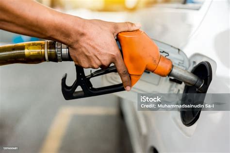 주유소에 자동차 급유직원 가솔린 오일을 펌핑 또는 따뜻한 일몰 교통 개념에 차량의 탱크에 넣어 연료 노즐을 처리합니다 가솔린에 대한 스톡 사진 및 기타 이미지 Istock