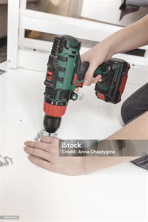 바닥에 흰색 접이식 테이블을 조립하는 무선 스크루 드라이버를 가진 젊은 여성 20 24세에 대한 스톡 사진 및 기타 이미지 20 24세 Diy Z세대 Istock