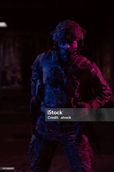 육군 엘리트 부대의 군인 마스크와 안경 얼굴 뒤에 숨겨진 특수 보안 서비스 전투기 헬멧 및로드 캐리지 시스템에서 서비스 권총 낮은 키를 목표로 겨냥에 대한 스톡 사진 및