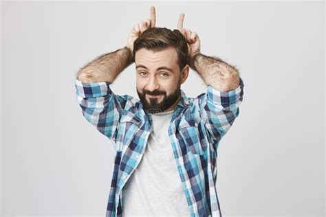 Handsome European Adult Guy With Beard And Moustache Showing Horns With