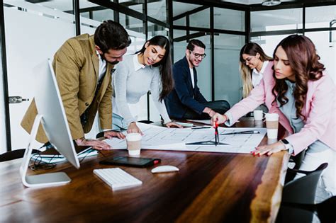 멕시코 라틴 아메리카의 창의적인 사무실에서 건축가 또는 디자이너 히스패닉 팀워크를 계획하고 인테리어 디자인 프로젝트 또는 건축 개발을 계획하고 작업하는 젊은 라틴계 사람들