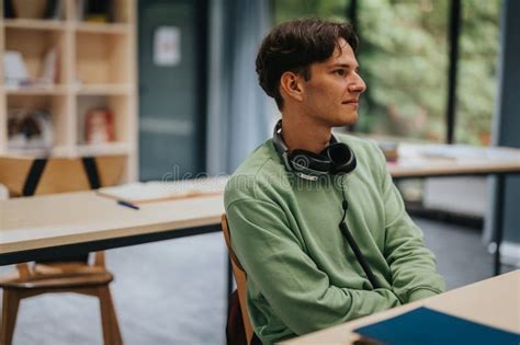 Young Man In A Classroom Setting With Headphones Around Neck Stock Image Image Of Focused