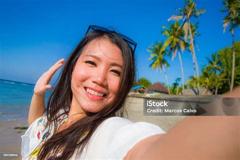 여름 휴가 여행 명랑 웃 고 즐기는 이국적인 열 대 해변에서 휴대 전화 카메라로 사진 화려한 아름 답 고 행복 한 아시아 한국어 또는 중국어 여자 20 대 복용 Selfie