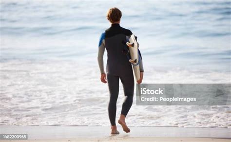 해변에서 서퍼 야외에서 스포츠를 즐길 수 있는 서핑보드를 탄 남자 바다 모형 공간과 자연과 함께 여행합니다 모험 익스트림 스포츠 운동선수 산책 활동적인 라이프스타일