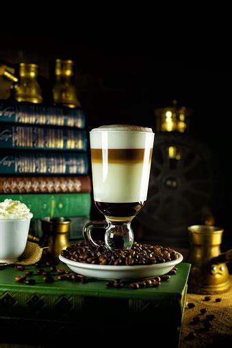 커피 포트 옆에 커피 원두에 라 떼 스탠드가 있는 큰 유리 오래 된 책 주위와 어두운 배경에 그 라인 더와 도서관의 분위기 0