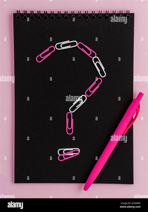 Question Mark Made Of Clips On Black Notebook Blank On Pink Background Flat Lay Stock Photo Alamy
