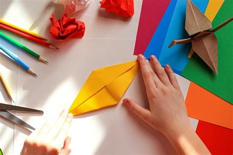 다양한 학교 용품흰색 종이에서 종이 접기 크레인을하고 아이들의 손 종이 접기의 단계별 튜토리얼 아이들의 창의력의 개념 다시 학교로 Diy에 대한 스톡 사진 및 기타 이미지