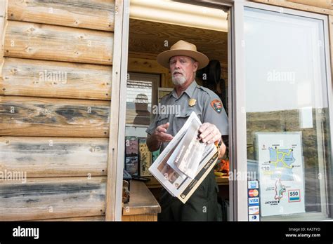 Male Park Ranger At The Entrance Booth Handing In Map And Park