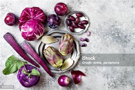 회색 콘크리트 배경 위에 원시 보라색 야채입니다 Radicchio 샐러드 올리브 알 줄기 양배추 당근 양파 아 티 초 크 콩 자 두 평면도 평평 하다 복사 공간 보라색에