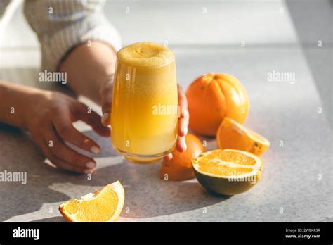 Freshly squeezed orange juice in female hands, close up Stock Photo - Alamy