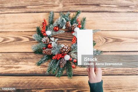 소녀는 크리스마스 화환과 나무 테이블의 배경에 엽서를 보유하고 있습니다 레이아웃 삽입할 장소 계절에 대한 스톡 사진 및 기타 이미지 Istock