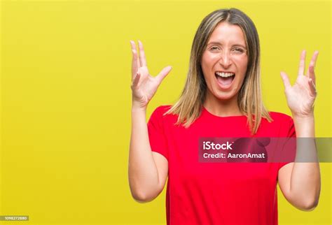 미친을 축 하 하 고 무기와 성공을 위한 흥분 비명 제기 및 오픈 눈 깜짝 놀라게 격리 된 배경 위에 젊은 아름 다운 여자