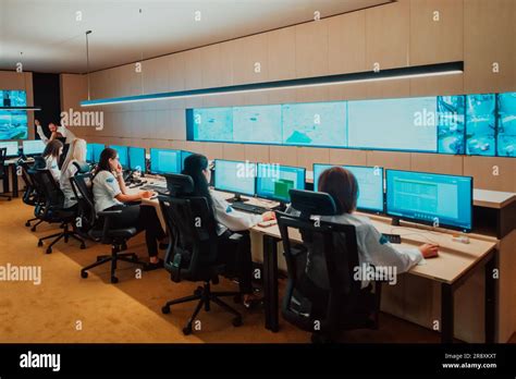 Group Of Security Data Center Operators Working In A Cctv Monitoring
