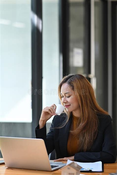 Businesswoman Sitting At Her Workplace And Drinking Coffee Stock Image
