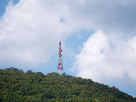 Directional Antenna Array On A Red And White Communication Tower