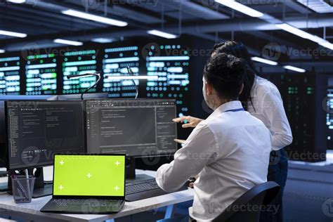 Team Of Technicians In Data Center Using Isolated Screen Laptop To Find