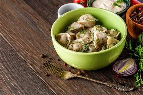 피에로기 또는 피로히 바레니키 바레니키 만두 나무 테이블에 그릇에 캐러멜화 소금양파와 함께 제공 전통적인 러시아 음식 펠메니 라비올리 감자 요리에 대한 스톡 사진 및 기타