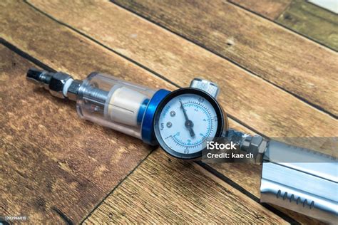 나무 바닥에 페인트 스프레이 산업 회화 및 코팅에 사용되는 산업 크기 스프레이 건을 들고 화가의 팔 손의 이미지 배경 클리핑