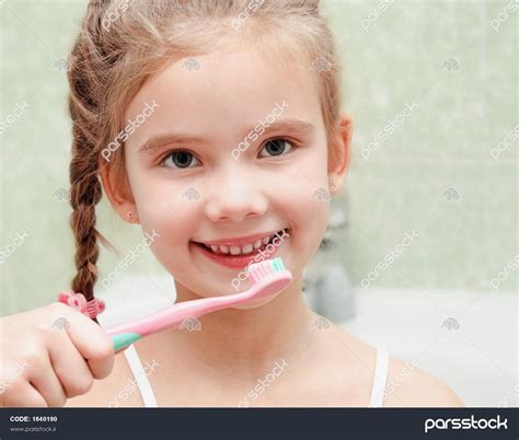 دختر کوچک ناز خندان در حال مسواک زدن در مفهوم بهداشت حمام 1640190