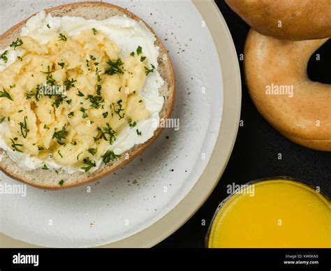 Scrambled Egg And Cream Cheese Bagel Against A Black Background Stock