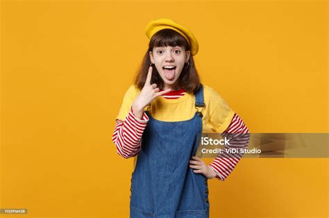 프랑스어 베 레모에서 재미 있은 소녀 십 대 혀를 보여주는 제스처는 무거운 금속 바위 기호 노란색 배경에 고립 된 락 앤 롤 묘사 사람들의 감정 라이프 스타일 개념입니다