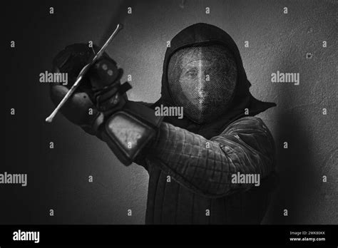 Portrait Of A Man Dressed In Black Historical Fencing Armor And Fencing