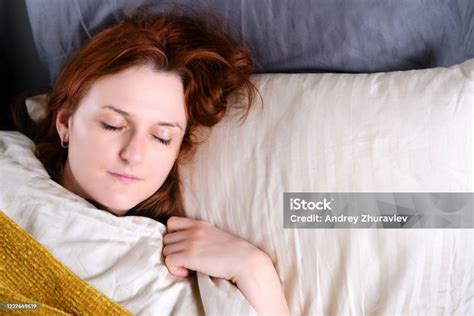 노란 담요와 흰색 베개가 있는 침대에서 자고 있는 빨간 머리의 여성이 텍스트를 위한 공간을 복사합니다 30 34세에 대한 스톡 사진 및 기타 이미지 Istock