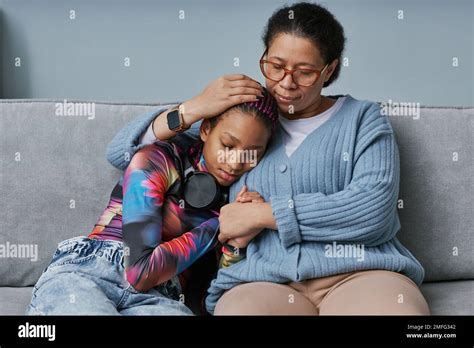 Portrait Of Mature Mother Embracing Teenage Daughter During Family Bonding Moment At Home Stock