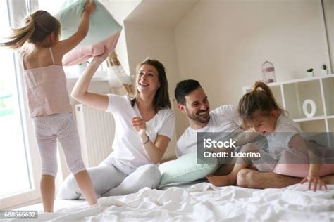 가족 재미 베개 침대에 싸우는 데입니다 부모 그들의 딸과 함께 자유 시간을 보내고입니다 베개와 싸움 4 명에 대한 스톡 사진 및 기타 이미지 Istock