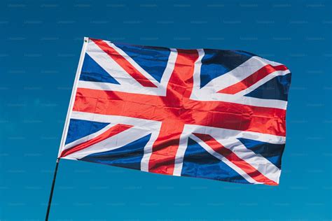 A British Flag Flying In The Blue Sky Photo British Flag Image On